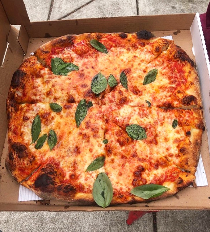 Pizza perfection doesn't need fancy toppings&mdash;just impeccable dough, bright sauce, quality cheese, and fresh basil leaves scattered like edible confetti.