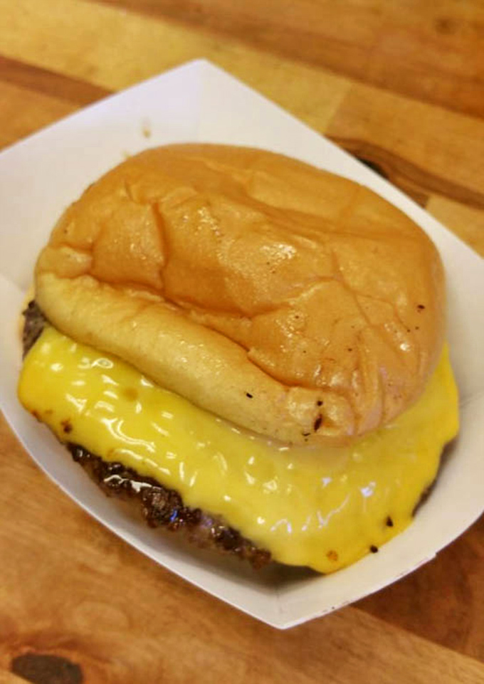 This isn't just a cheeseburger&mdash;it's a statement piece. The melted American cheese blankets the patty like a comfort food comforter on a meat mattress.