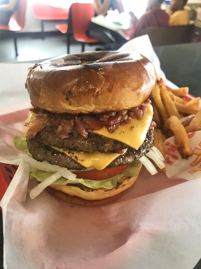 This isn't just a burger; it's a skyscraper of flavor. Two patties, melty cheese, and bacon create a masterpiece that requires both hands and possibly a building permit.