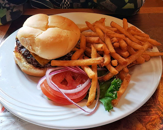 A burger that requires both hands and a strategy. Those fresh toppings and golden fries aren't just accompaniments—they're supporting actors in a delicious drama.