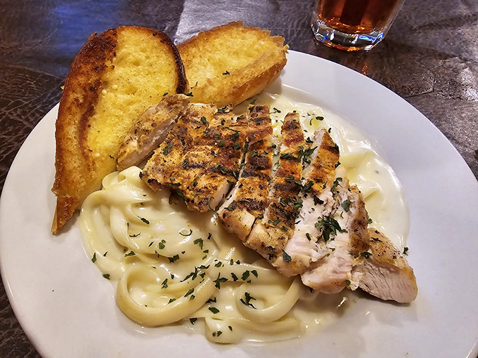 Grilled chicken resting on a cloud of alfredo pasta &ndash; proof that sometimes the classics endure because they're simply unbeatable.