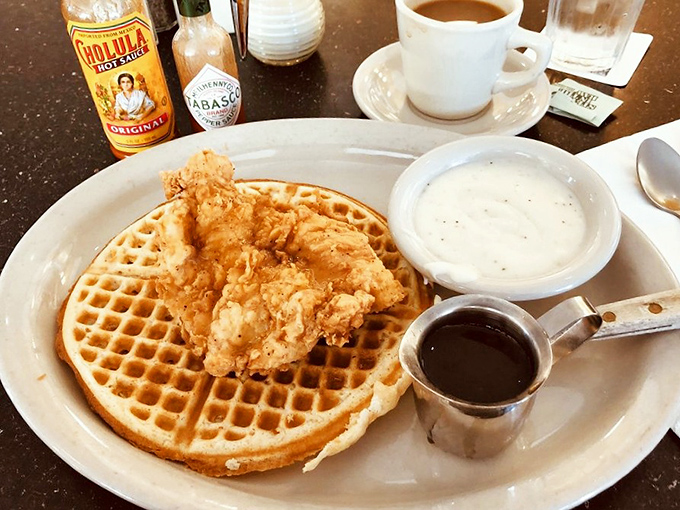 The eternal breakfast debate&mdash;sweet or savory&mdash;beautifully resolved with crispy golden chicken perched atop a fluffy waffle. Maple syrup and hot sauce standing by for your personal preference.