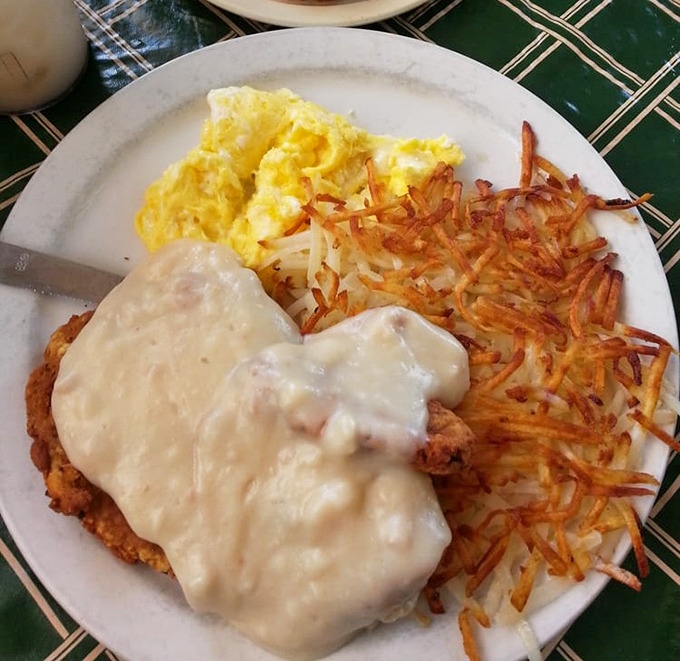Chicken fried steak smothered in country gravy &ndash; comfort food that hugs your soul while those hash browns achieve the perfect crisp-to-tender ratio.