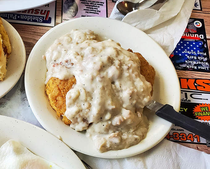 This chicken-fried steak hiding under a blanket of country gravy isn't just a meal—it's a warm, peppery hug on a plate.