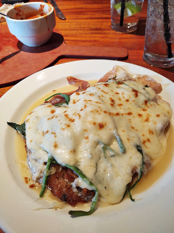 This chicken parmigiana isn't just covered in cheese&mdash;it's wearing a melted masterpiece like it's walking the red carpet of Italian-American cuisine.