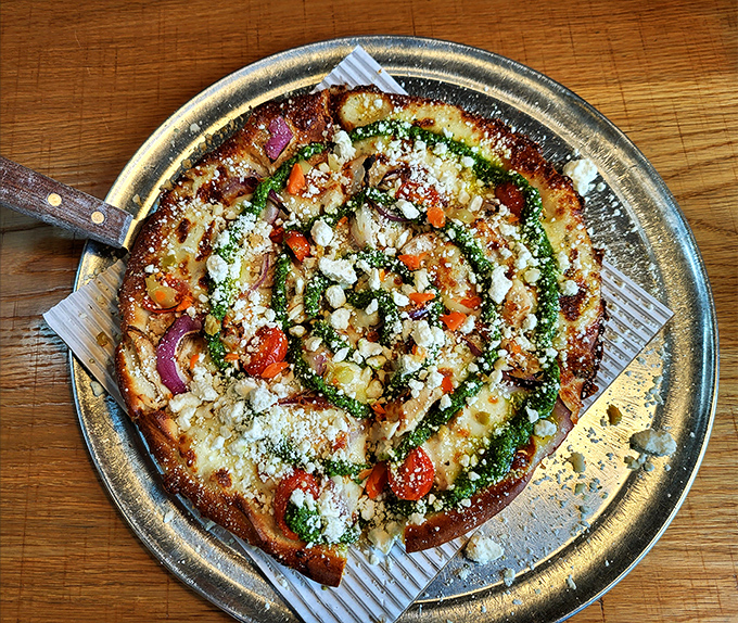 A pizza garden blooms with fresh herbs, roasted vegetables, and feta—proof that vegetarian options can steal the spotlight.