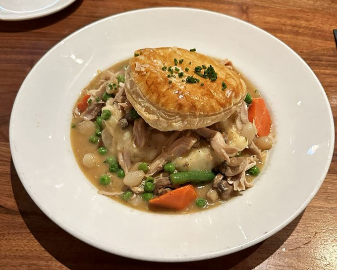 Beneath that golden pastry dome lies chicken pot pie nirvana&mdash;a steaming treasure chest of tender meat and vegetables swimming in velvety gravy.