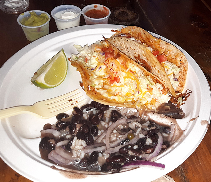 Fish tacos and black beans&mdash;a plate that screams "vacation" louder than your Hawaiian shirt. The lime isn't optional, it's essential.