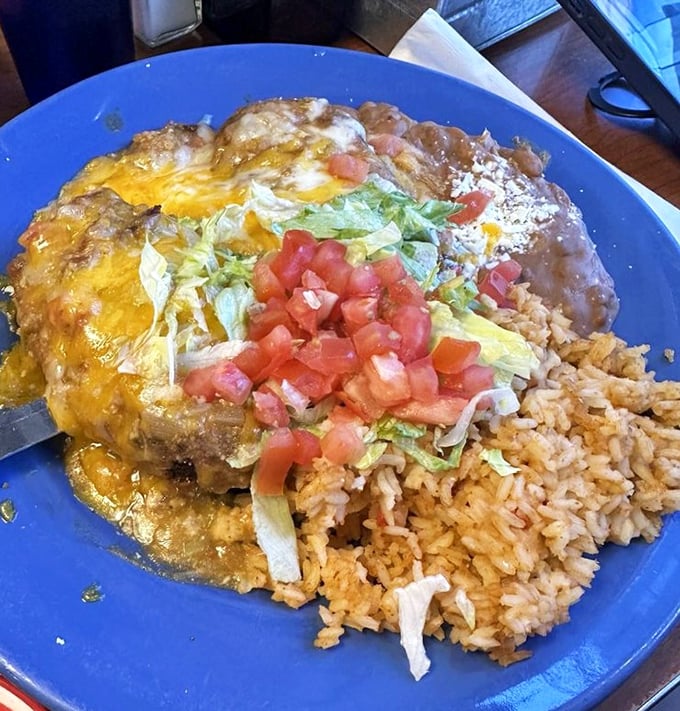 When a burrito gets the royal treatment: smothered in melted cheese, green chili, and topped with fresh lettuce and tomato. Resistance is futile.