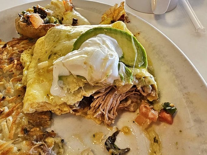 The legendary chili verde in all its glory. Tender pork nestled in a vibrant sauce with avocado and sour cream - breakfast architecture at its finest.