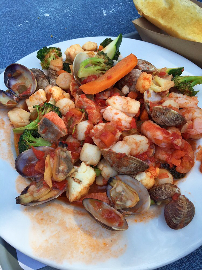 The legendary cioppino—a seafood United Nations where clams, mussels, shrimp, and fish gather in tomato-broth harmony. Worth wearing a bib for!