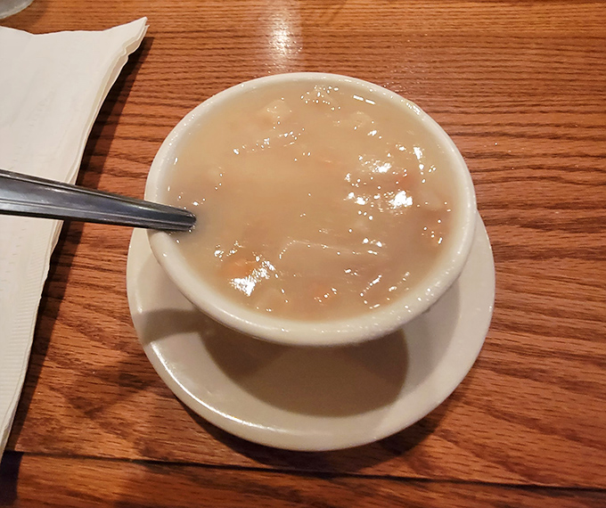 The clam chowder arrives like a warm hug in a bowl, creamy and comforting—the perfect prelude to the meaty main event.