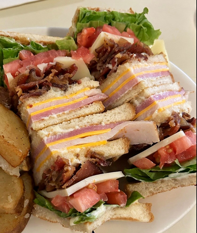 The club sandwich&mdash;architecture you can eat. Layers of satisfaction stacked between toasted bread with home fries standing guard.