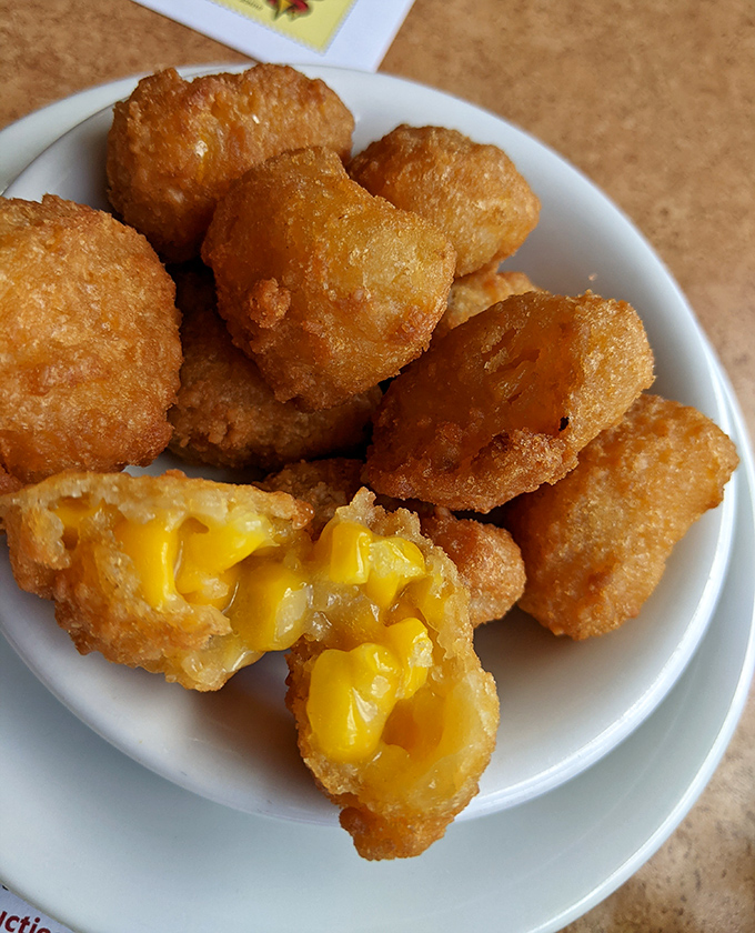 These corn fritters reveal their molten cheese centers like tiny golden treasures. One bite and you'll understand why people can't stop at just one.