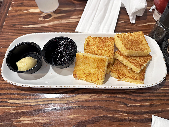 Golden squares of cornbread that hover between dessert and side dish. That butter and jam pairing? Pure genius that your grandmother would approve of.