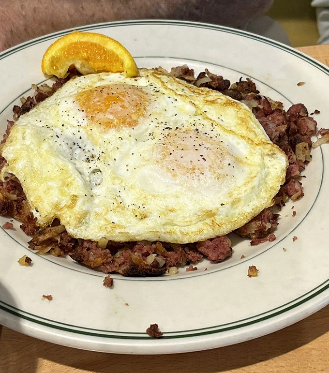Sunny-side up eggs atop a bed of corned beef hash—proof that breakfast is the most important art form of the day.