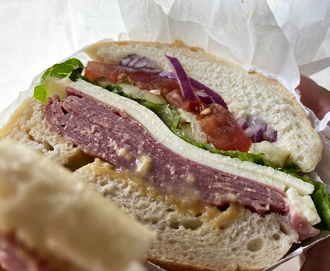 A proper sandwich should require both hands and a strategy. This corned beef creation demands respect, patience, and possibly an extra napkin or three.
