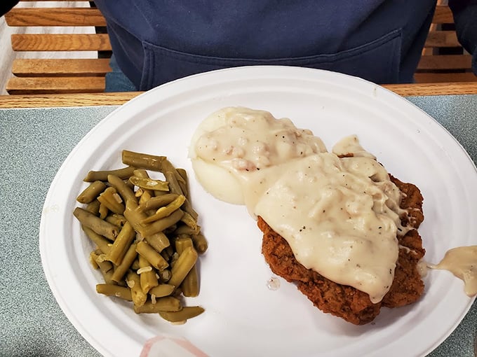 Country fried steak smothered in gravy with green beans standing by. Not all heroes wear capes; some wear crispy breading.