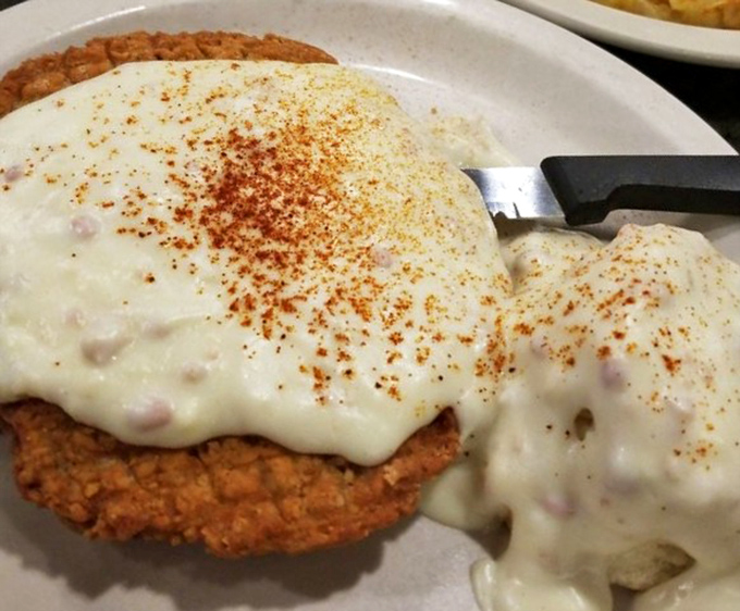 Country fried steak smothered in creamy gravy with a dusting of paprika&mdash;comfort food that hugs your soul while simultaneously plotting against your arteries.