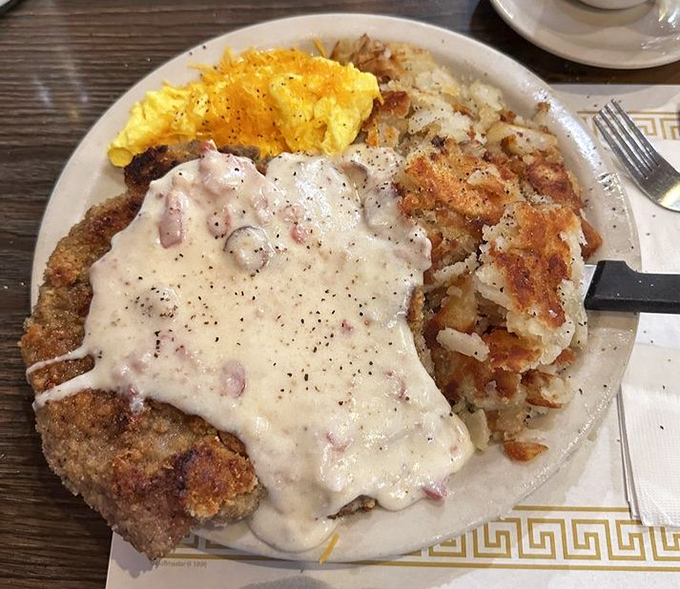 Country fried steak &ndash; where a humble cut of beef transforms into something transcendent under a blanket of peppery gravy. This is breakfast as an art form.