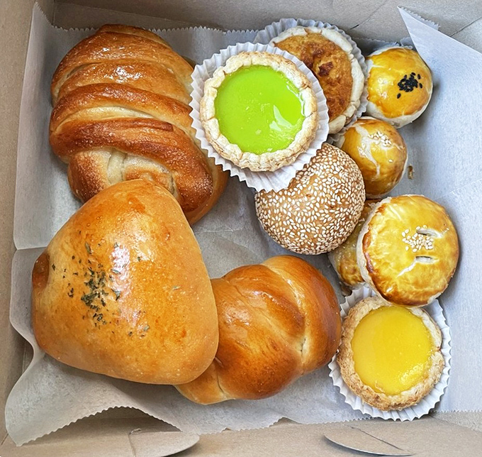 A bakery box that doubles as a treasure chest: croissants, egg tarts, and that vibrant matcha tart that's practically winking at you.
