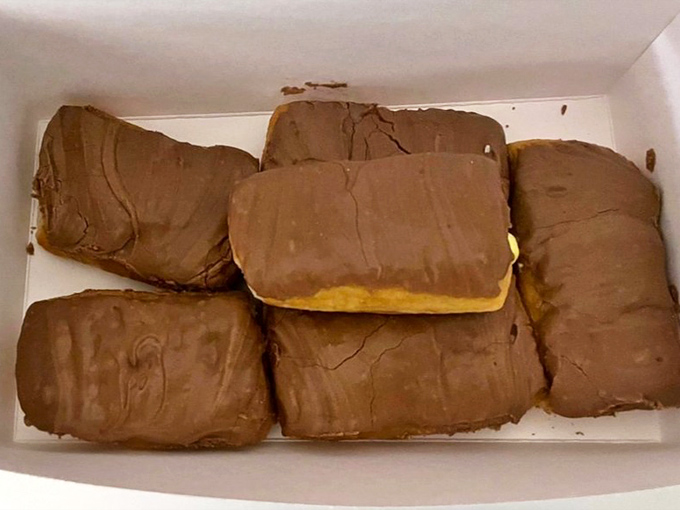 Long Johns lined up like delicious chocolate-covered submarines. These aren't just eclairs&mdash;they're vessels of joy waiting to transport you to happiness.
