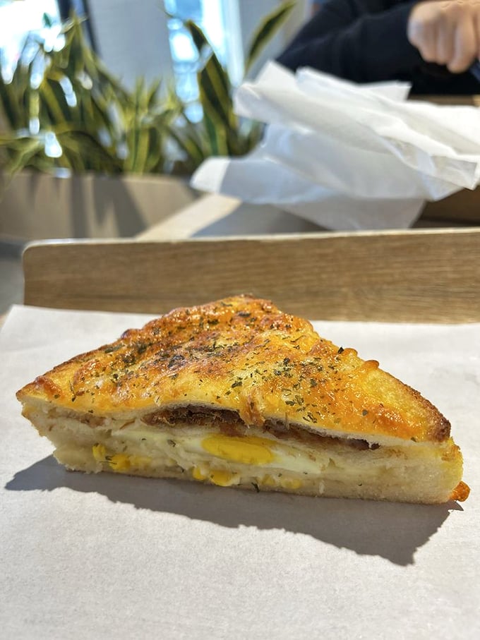 This isn't just a sandwich; it's architecture. Layers of egg, corn, and cheese between perfectly toasted bread&mdash;the Taj Mahal of breakfast.