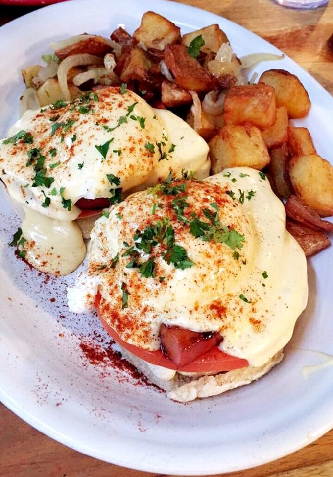 Eggs Benedict reimagined with a sprinkle of paprika and fresh herbs&mdash;proof that classics become legendary when executed with this level of care.