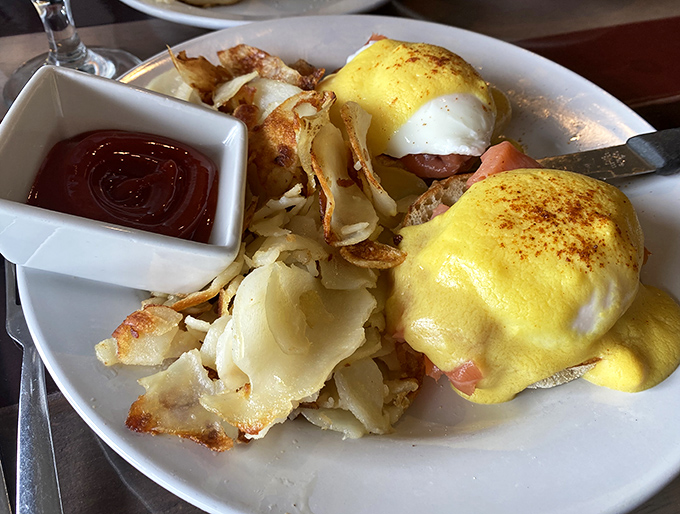 Eggs Benedict that would make a Canadian proud. Those golden hollandaise caps sit like sunshine atop perfectly poached eggs—breakfast architecture at its finest.
