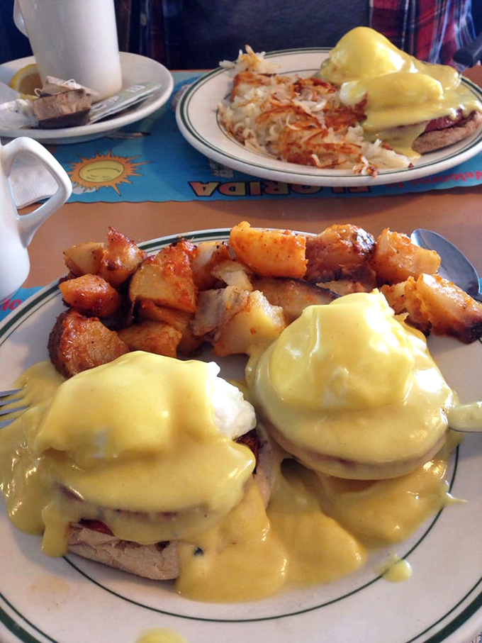 Eggs Benedict done right: perfectly poached eggs perched atop Canadian bacon, draped in hollandaise that cascades like a yellow waterfall of happiness.