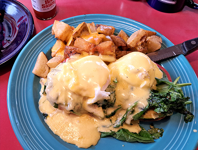 Eggs Benedict reimagined with fresh greens and golden potatoes &ndash; a breakfast that demands to be photographed before devoured.