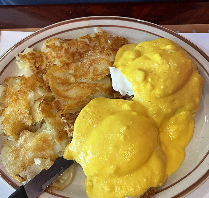 Eggs Benedict: where hollandaise sauce flows like liquid gold over English muffin islands. The hash browns provide the perfect crispy counterpoint.
