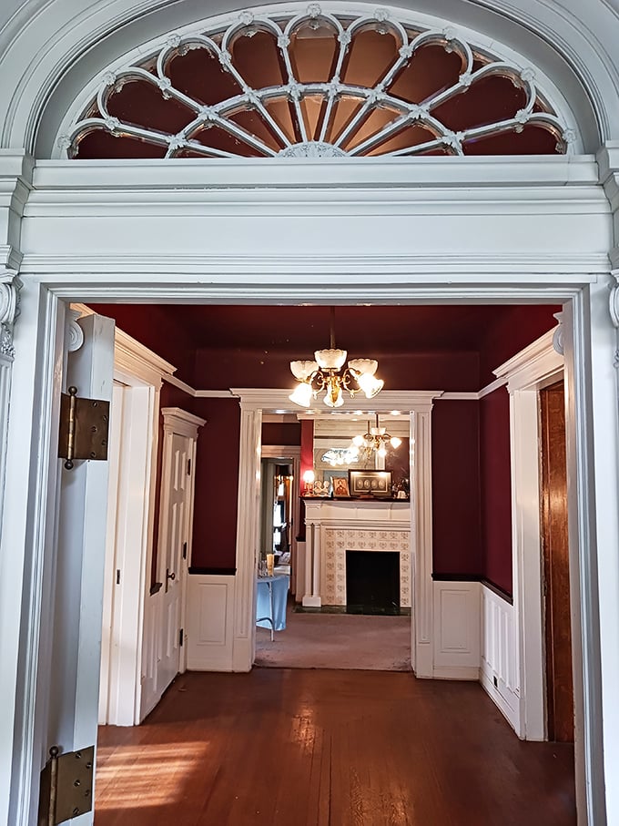 Step through this doorway and you've officially time-traveled. The fanlight arch and deep red walls create the perfect Victorian welcome committee.