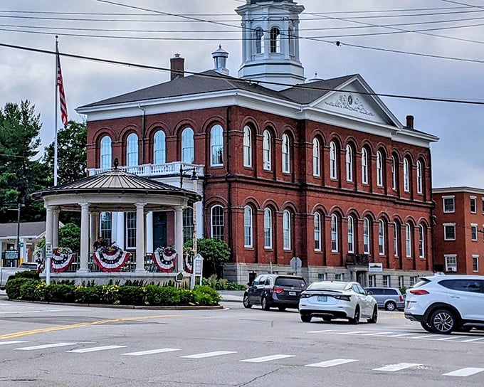 The stately brick town hall stands sentinel beside Exeter's bandstand, both dressed in patriotic bunting like they're posing for a postcard of American small-town life.