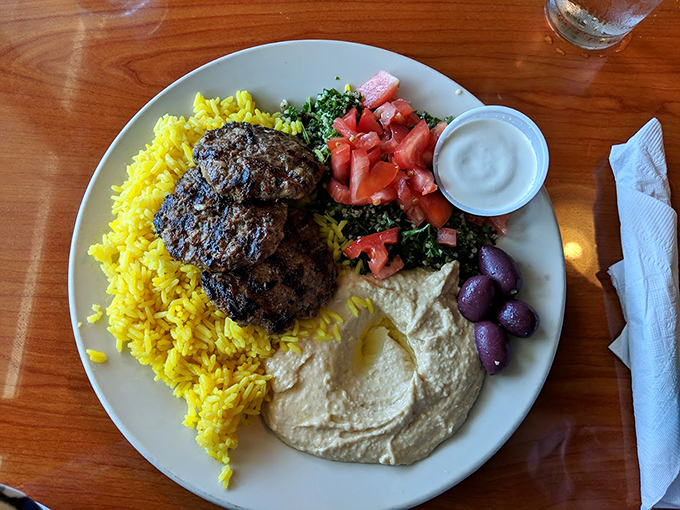 The kofta platter arrives like a complete Mediterranean vacation on a single plate. Yellow rice, hummus, tabbouleh&mdash;a passport isn't required.