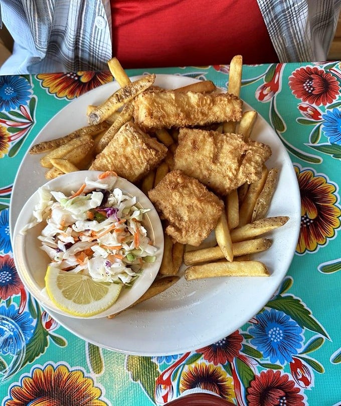 Golden-battered fish that shatters with each bite, alongside perfectly crisp fries and fresh slaw &ndash; the holy trinity of coastal comfort food.