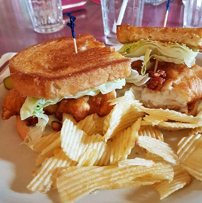 This sandwich isn't messing around. Crispy fish, fresh lettuce, and toasted bread create the holy trinity of lunch perfection, with chips standing guard.