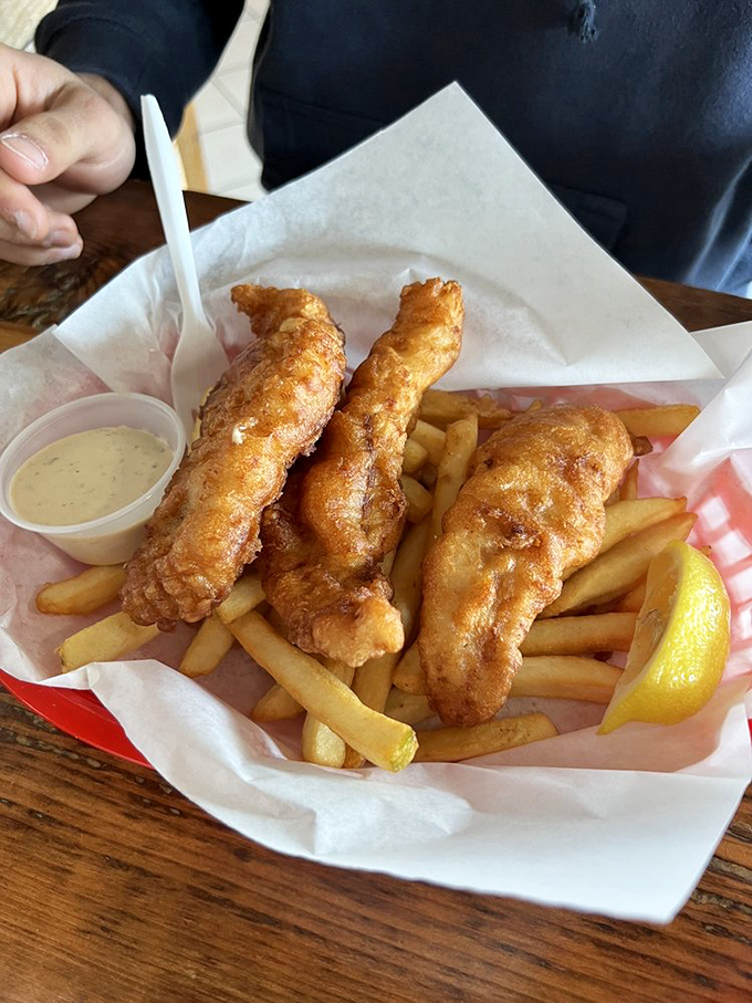Golden-battered fish fillets that shatter with each bite, paired with fries that achieve that mythical crisp-outside-fluffy-inside perfection. The lemon wedge isn't optional&mdash;it's essential.