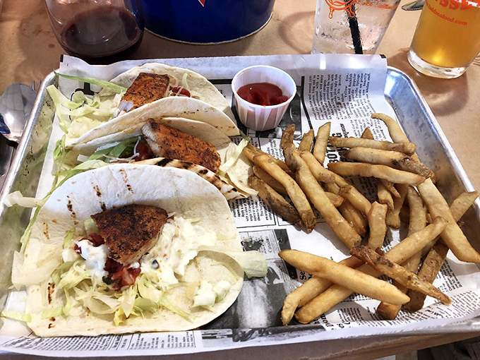 Fish tacos arrive with golden fries and a splash of color &ndash; blackened fish nestled in soft tortillas with crisp cabbage and a drizzle of sauce.