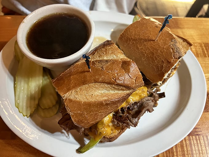 The French Dip sandwich &ndash; where thinly sliced beef meets crusty bread in a marriage blessed by a cup of savory au jus. Pickle on the side for good measure.