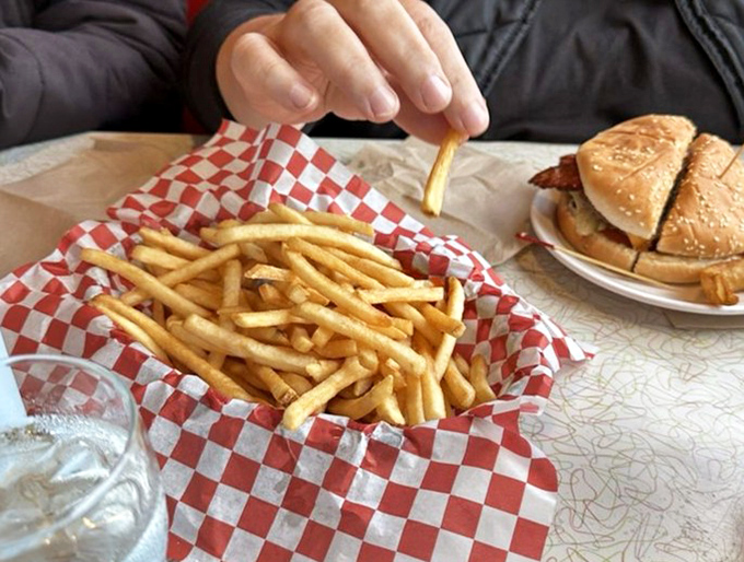 Golden, crispy french fries served in classic red checkered paper &ndash; the perfect supporting actor to the burger's starring role.