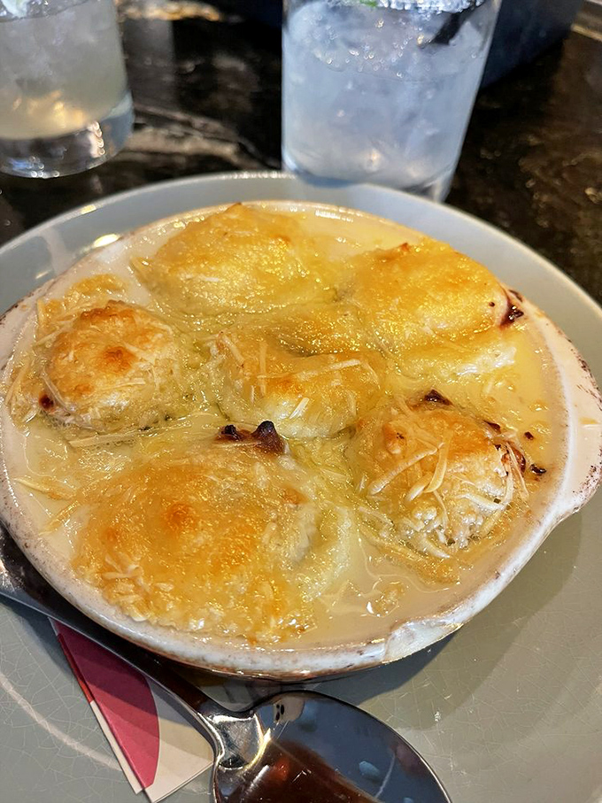 Bubbling French onion soup with a crown of melted cheese that stretches with each spoonful—comfort food wearing a beret.