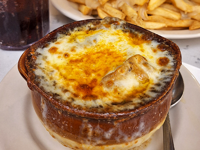 French onion soup with a cheese pull that deserves its own Olympic event. That golden dome of broiled perfection is the cathedral of comfort food.