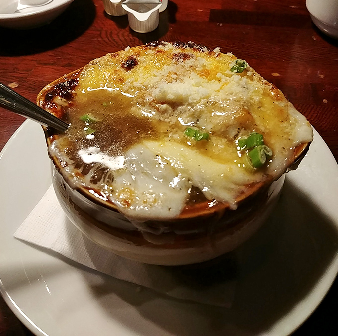 Bubbling cheese creates the perfect golden canopy over this French onion soup. It's not just a starter&mdash;it's a warm hug in a ceramic crock.