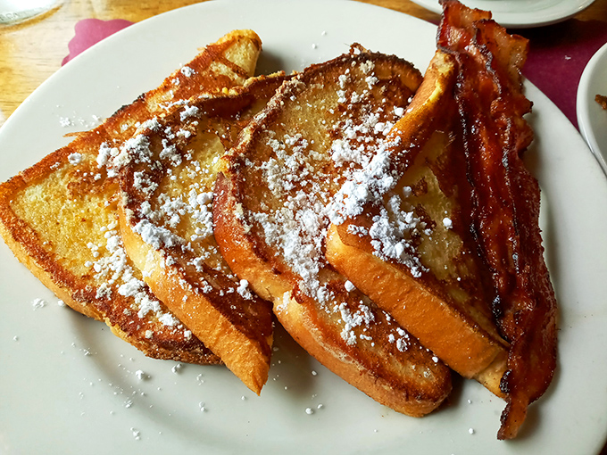 French toast that's dressed up for the occasion, dusted with powdered sugar like the first snow of winter. That bacon looks ready for its close-up.