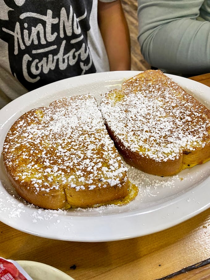 French toast so magnificent it deserves its own ZIP code. That powdered sugar dusting? The breakfast equivalent of freshly fallen snow.