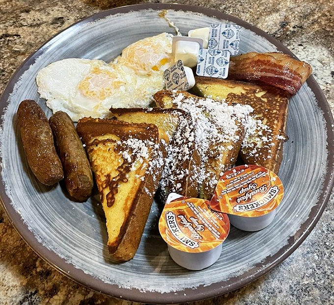 French toast that's dressed for success with powdered sugar snow, sausage sidekicks, and eggs that know exactly what they're doing.