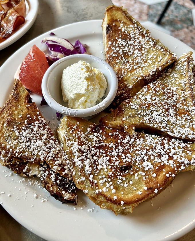 French toast that's dressed for success with powdered sugar snowfall and a dollop of butter melting like a summer romance. Breakfast doesn't get more photogenic than this.