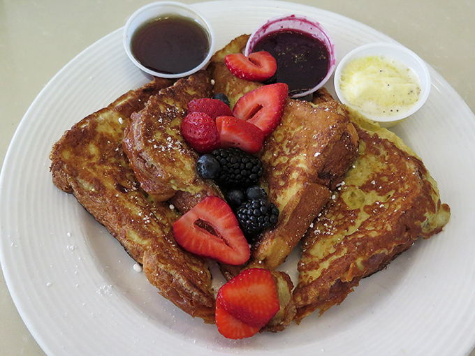 French toast that's achieved the impossible: crispy edges giving way to a custardy center, topped with berries that pop like tiny flavor fireworks.