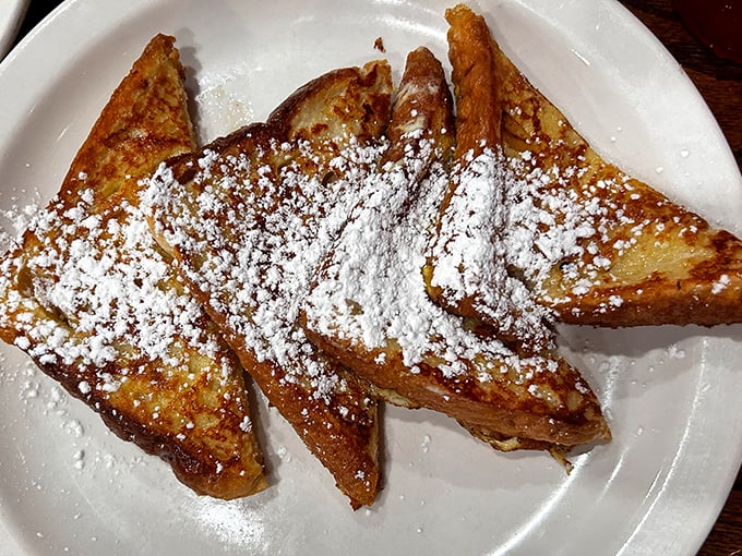 French toast that's achieved the impossible balance: crispy edges, custardy centers, and enough powdered sugar to make your inner child high-five your adult self.
